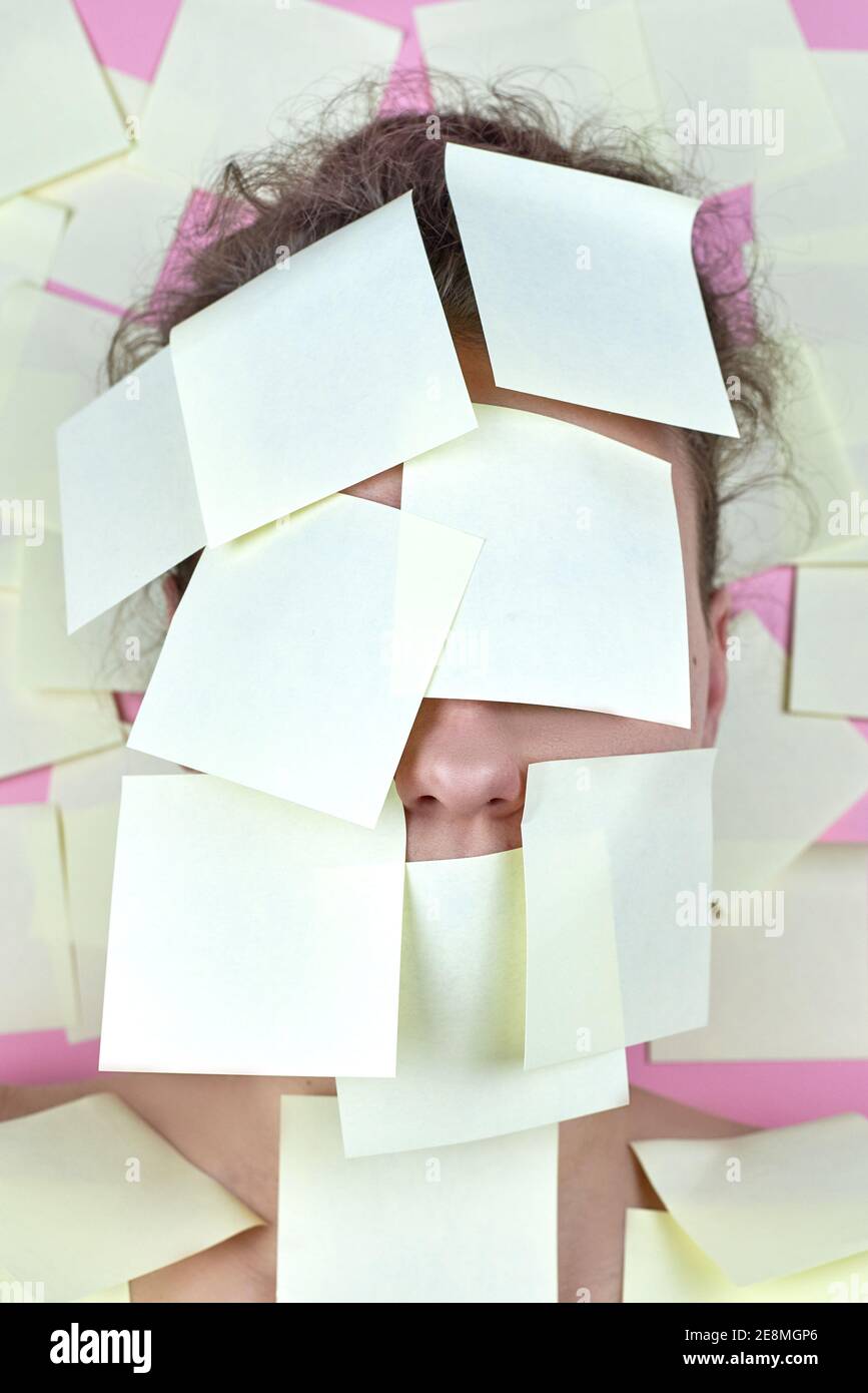 The woman's face is pasted over with blank stickers on a pink ...