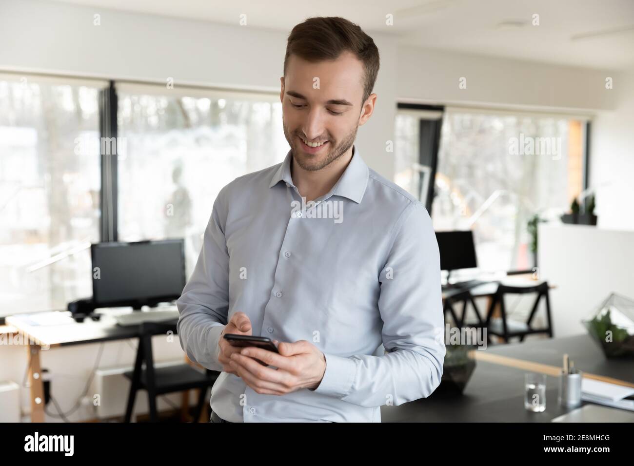 Happy male employee using app on cellphone Stock Photo - Alamy