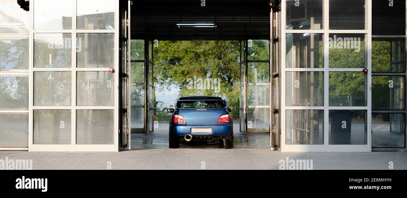 a blue sport car inside the self washing station box Stock Photo - Alamy