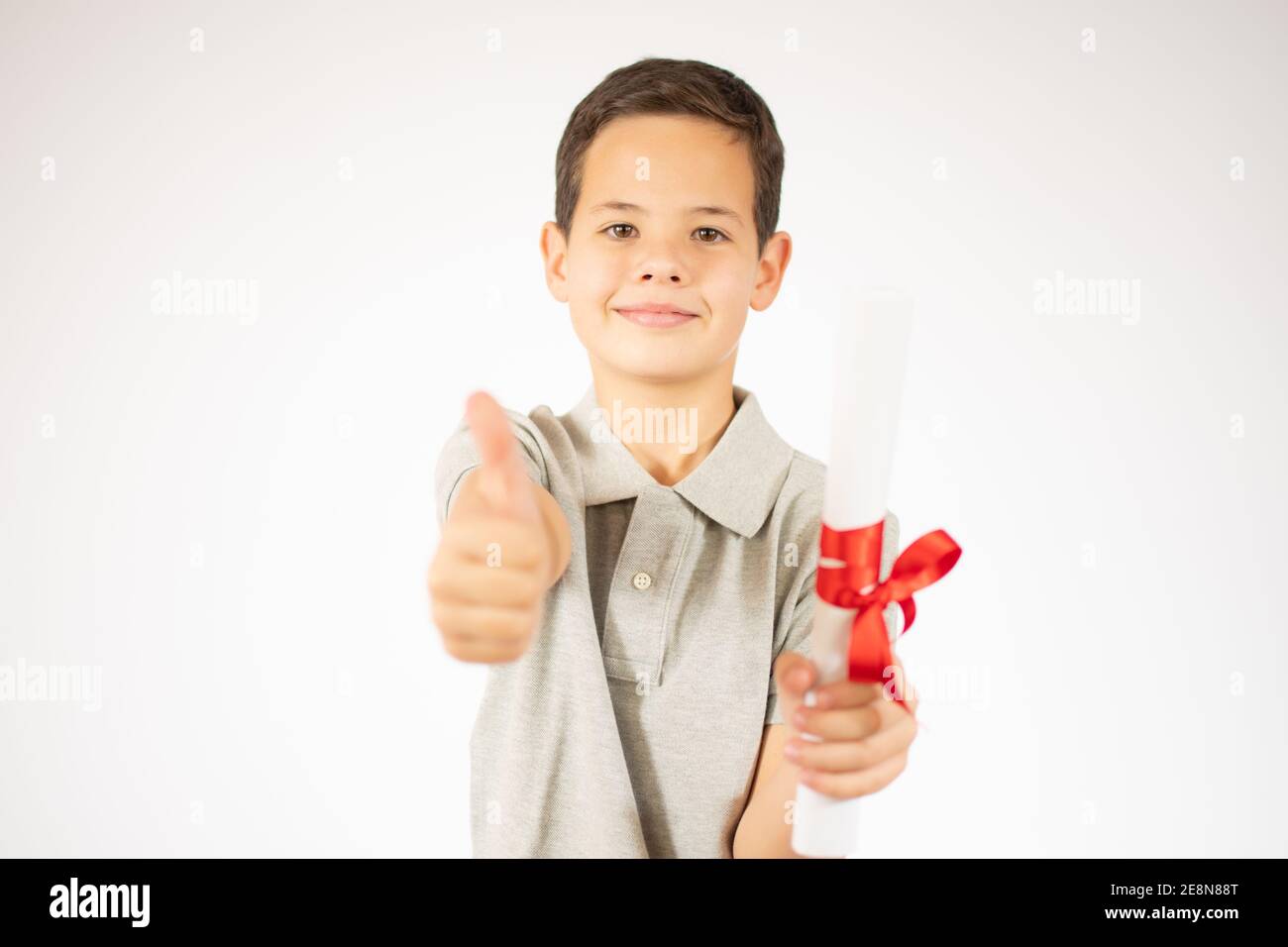 Young boy holding graduate degree diploma over white background Stock ... Young boy holding graduate degree diploma over white background Stock ...