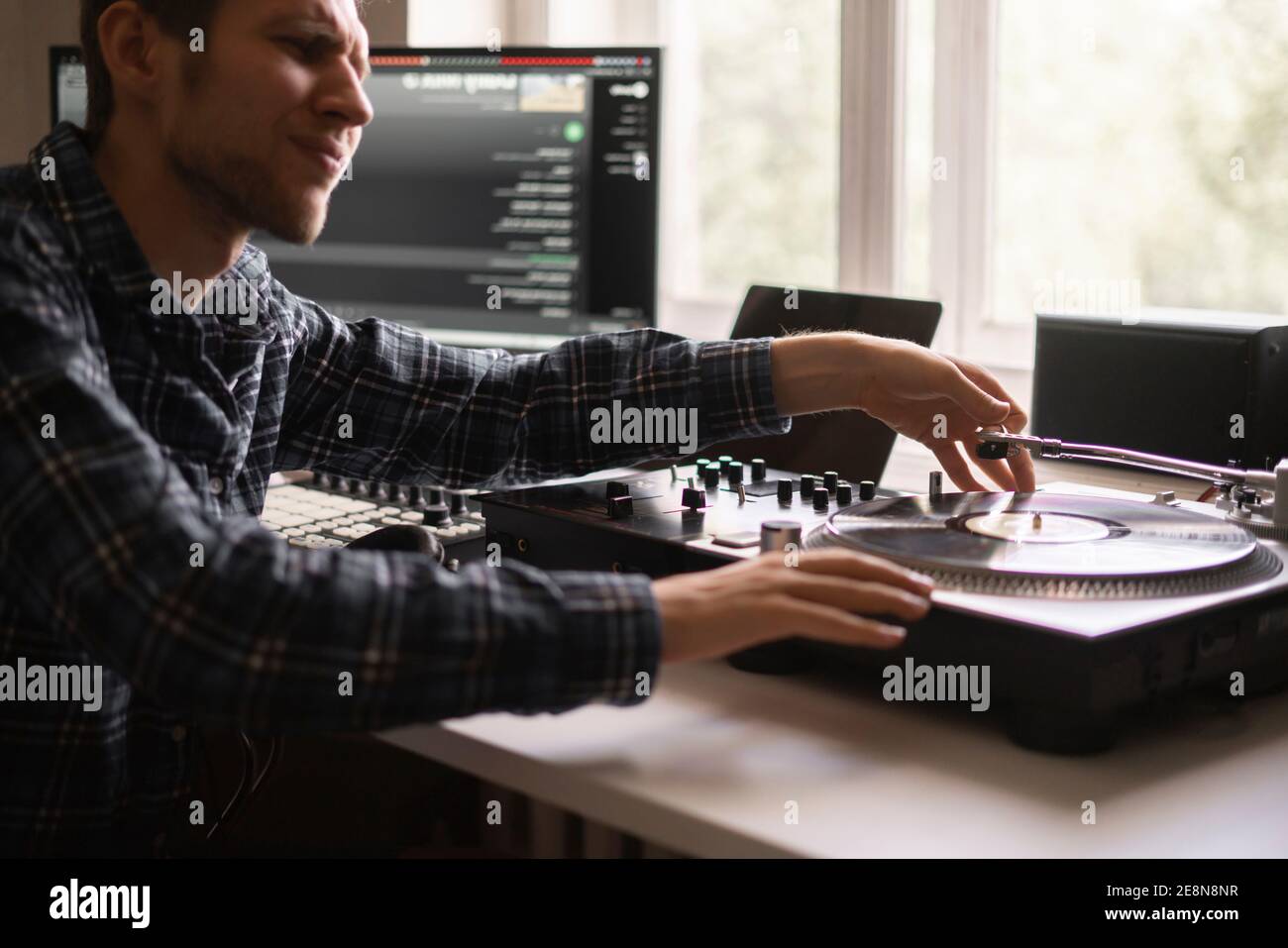 young male sound engineer working on a new music project in the studio ...