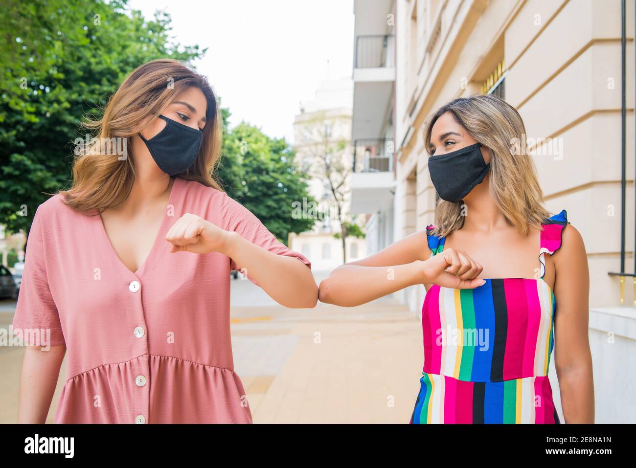 Two friends bumping elbows outdoors Stock Photo - Alamy