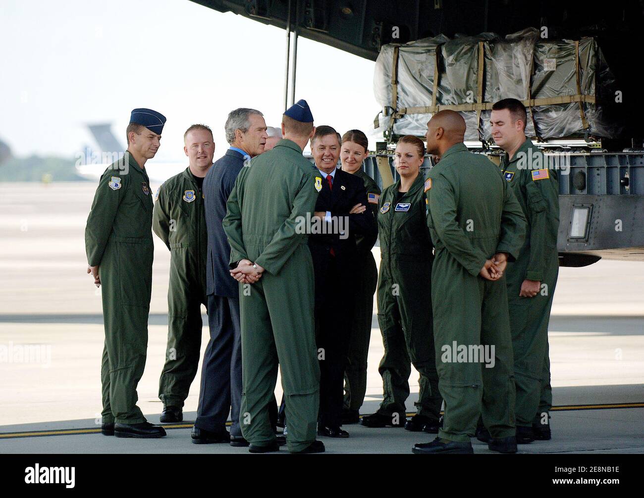 President George W. Bush discusses with military personnel during a ...