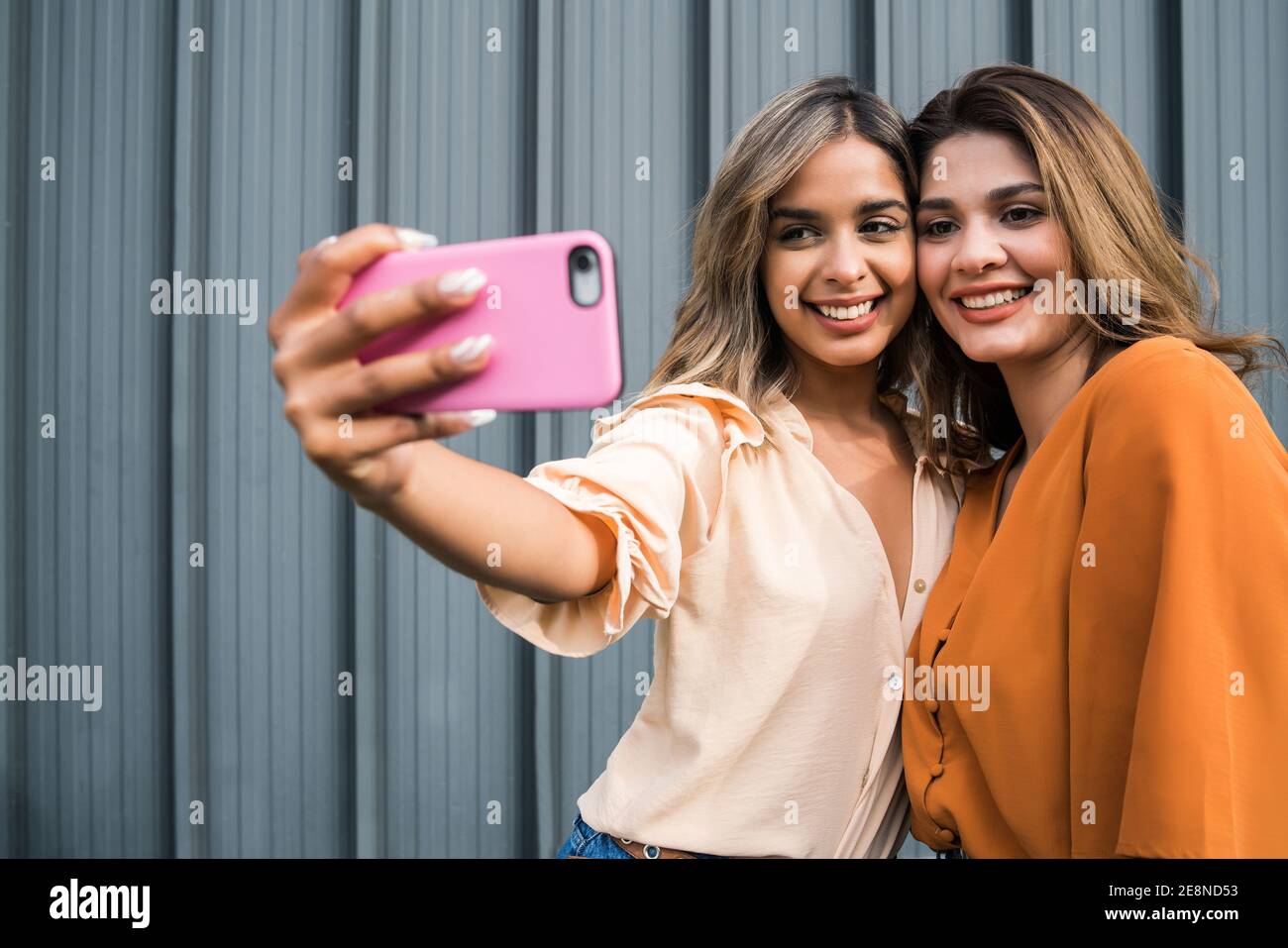 Two friends taking selfie with phone outdoors Stock Photo - Alamy