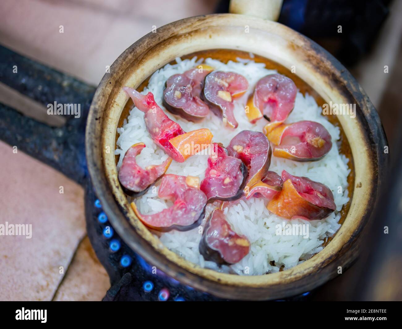 Close up shot of cooking the traditional eel fish claypot rice at Macau ...