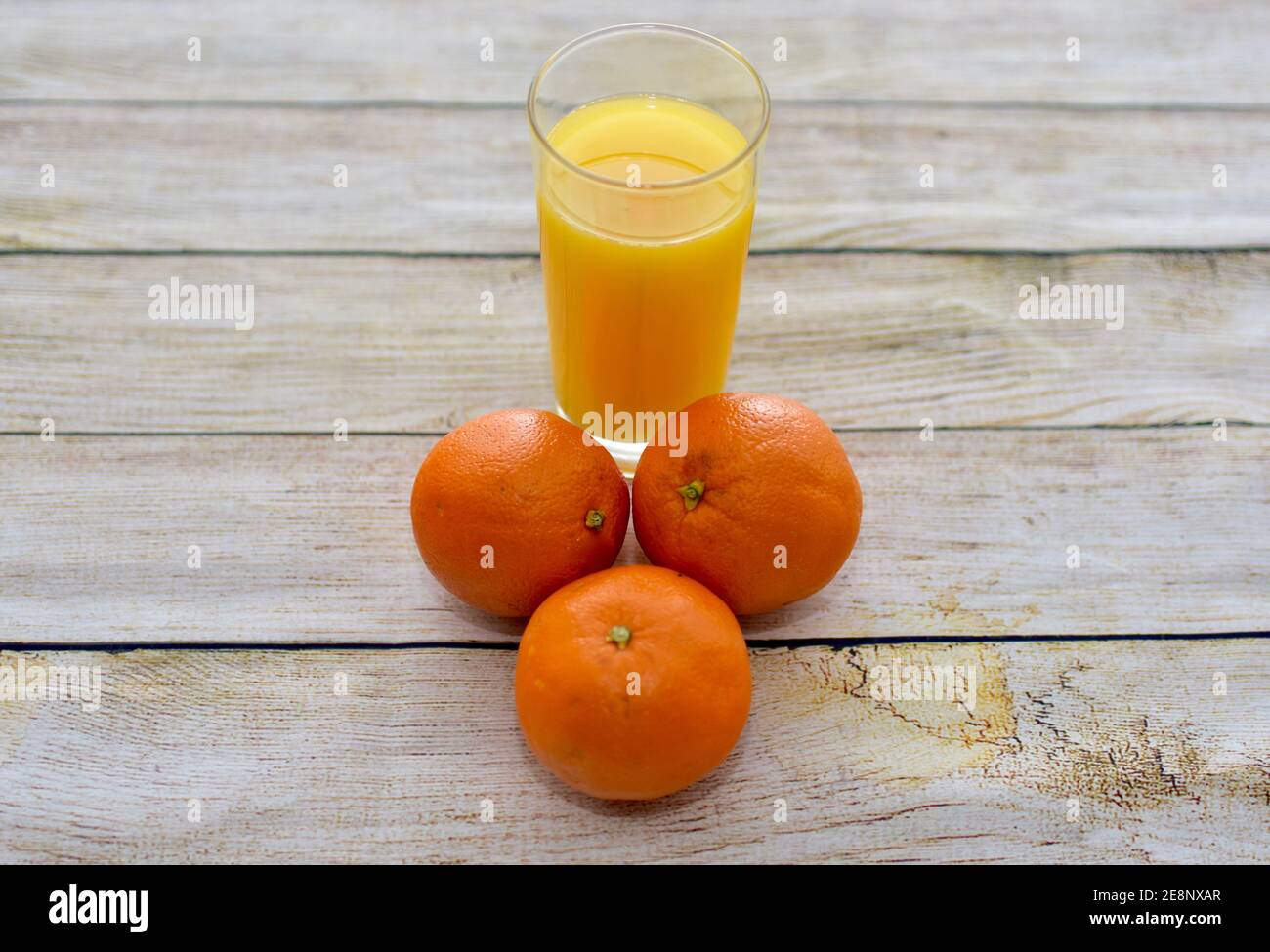 Fresh squeezed healthy orange juice and whole navel oranges close up ...