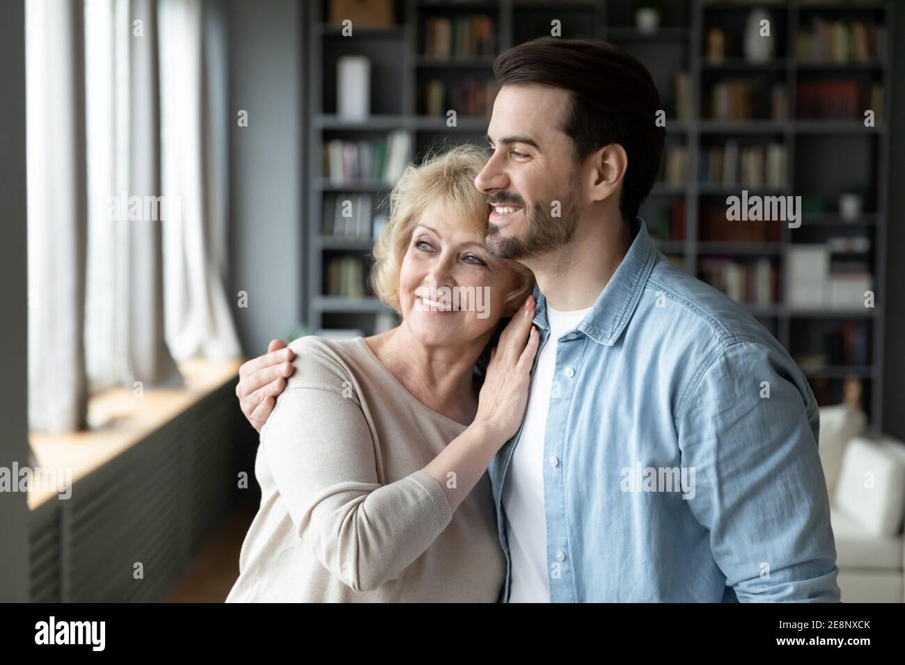 Happy dreamy affectionate bonding two generations family looking in ...