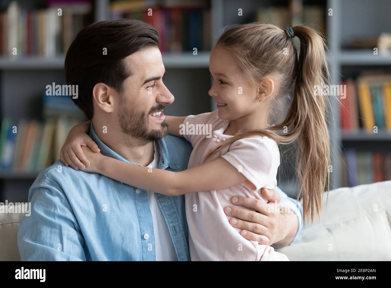 Affectionate caring young smiling father cuddling little daughter Stock ...