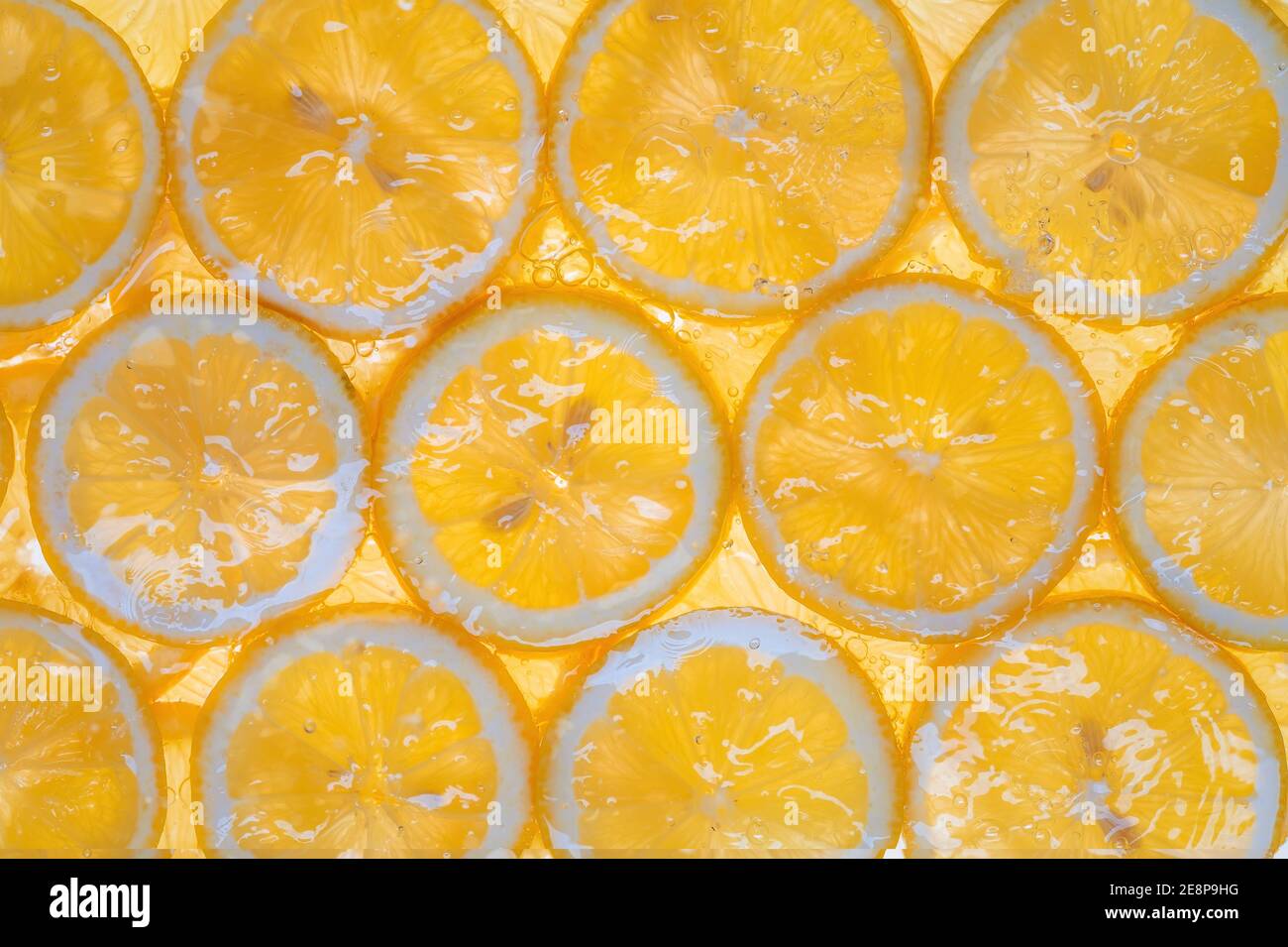 Slices of fresh lemon under water textured background Stock Photo - Alamy