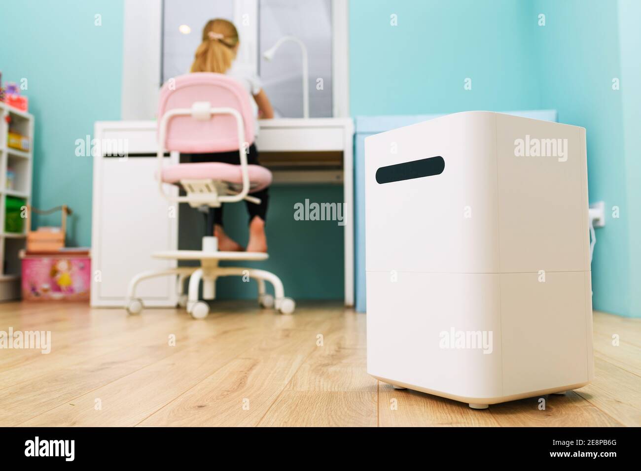 Big square white humidifier box in room with child sitting on desk at ...
