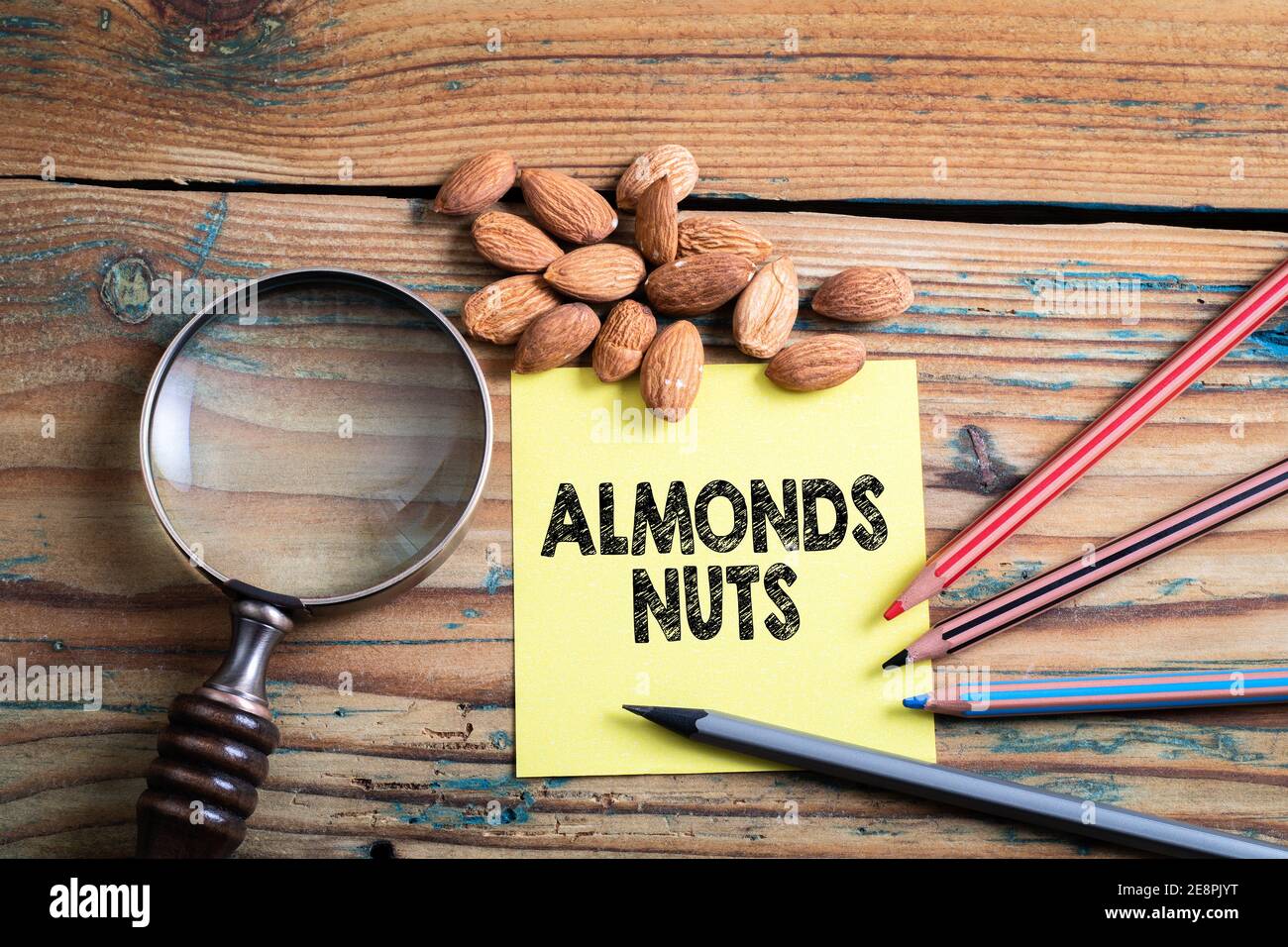 Almonds Nuts. Piece of paper, colored pencils and a magnifying glass on ...