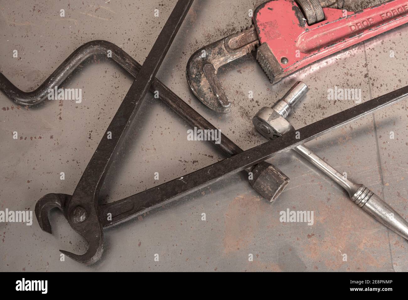 Vintage tools haphazardly arranged on a metal background with ...
