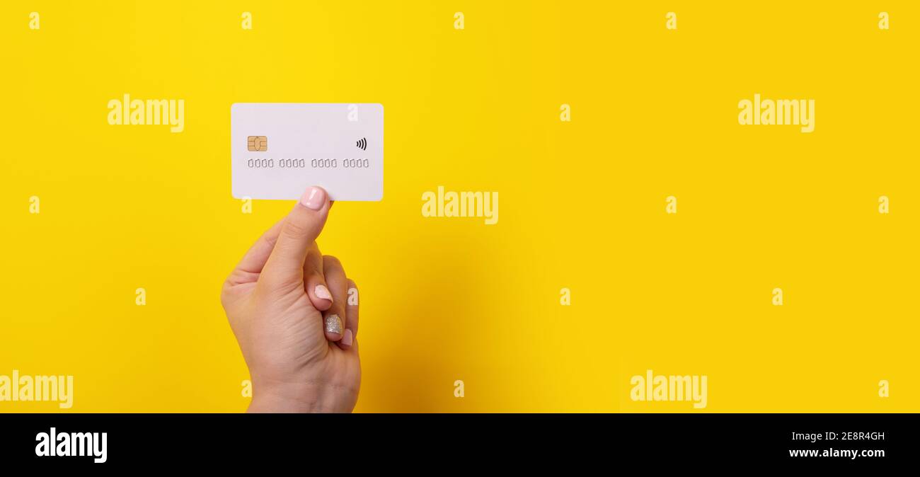 credit card in hand over yellow background, panoramic image Stock Photo ...