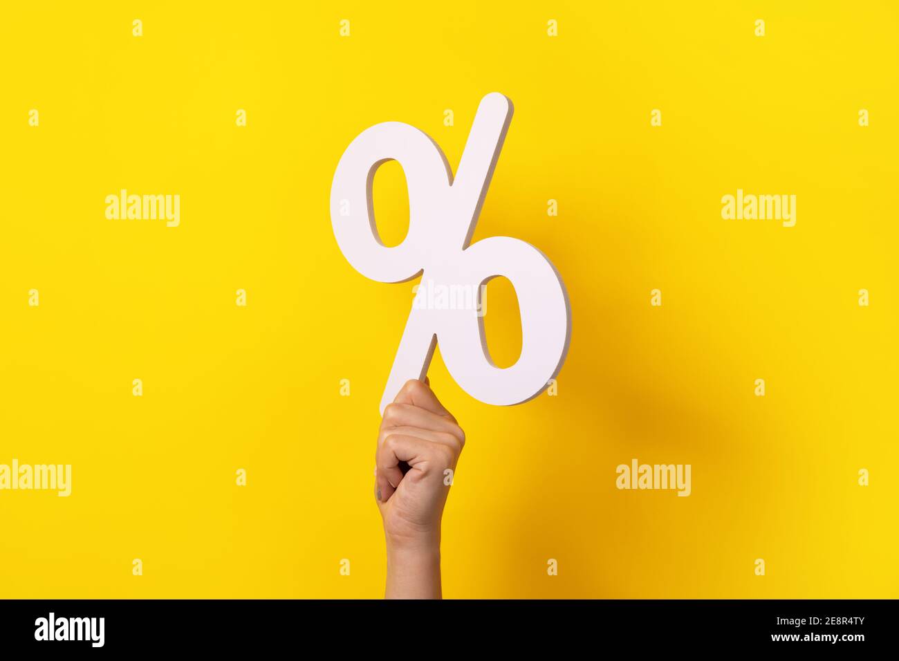 hand holding percentage sign over yellow background Stock Photo - Alamy