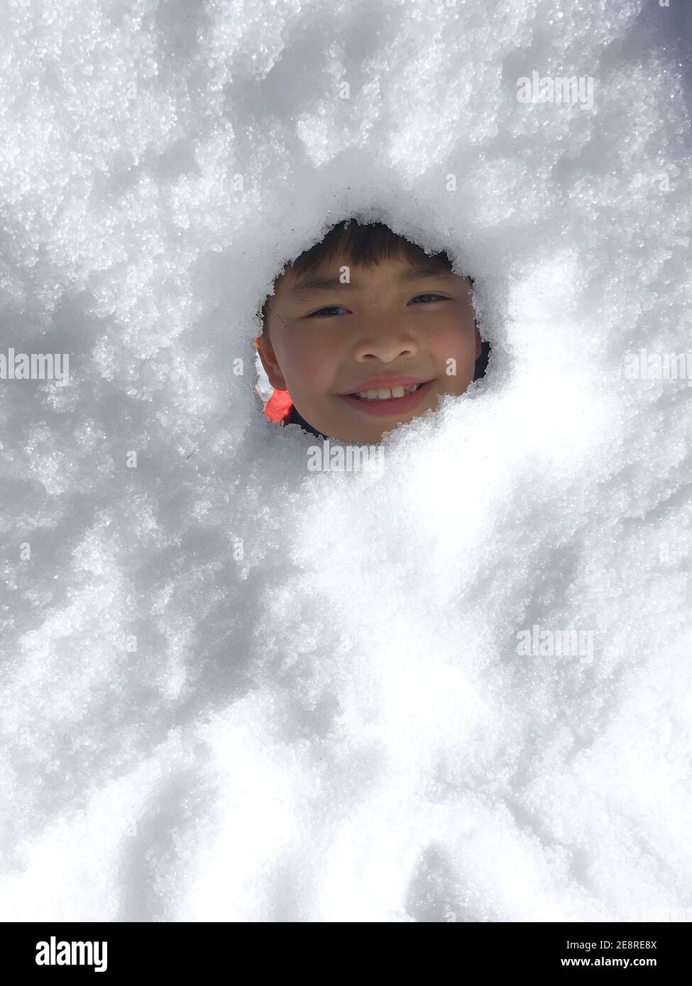 Happy boy playing in snow Stock Photo - Alamy