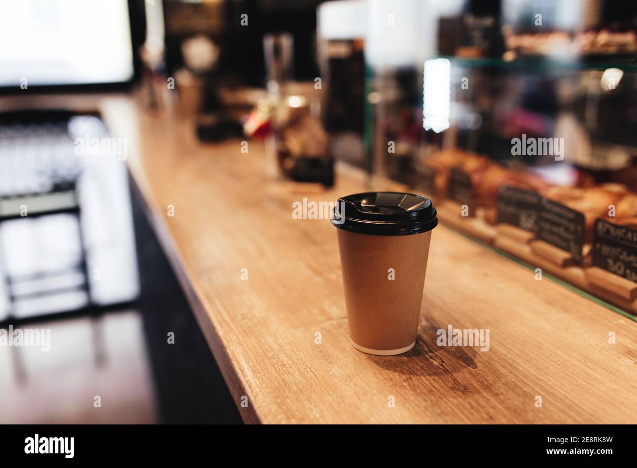 Paper coffee cup on bar counter in cafe. Blurred background Stock Photo ...