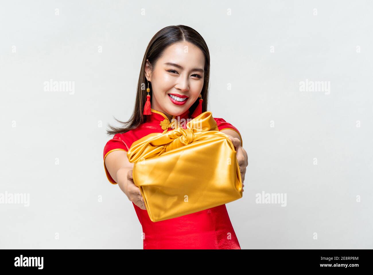 Portrait of smiling Asian woman in red traditional dress costume giving ...