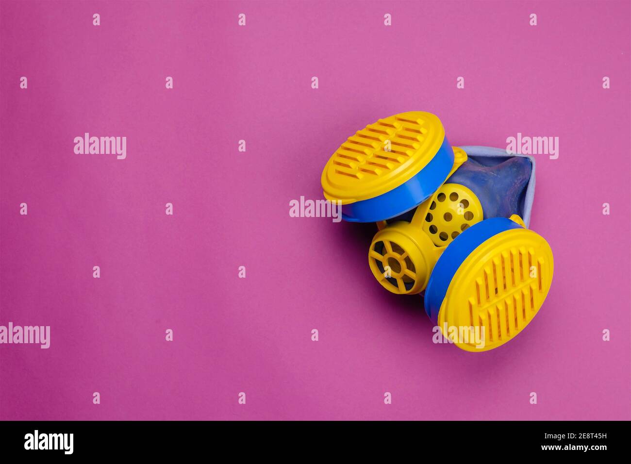 Yellow and blue respirator on a pink background. A special means of ...