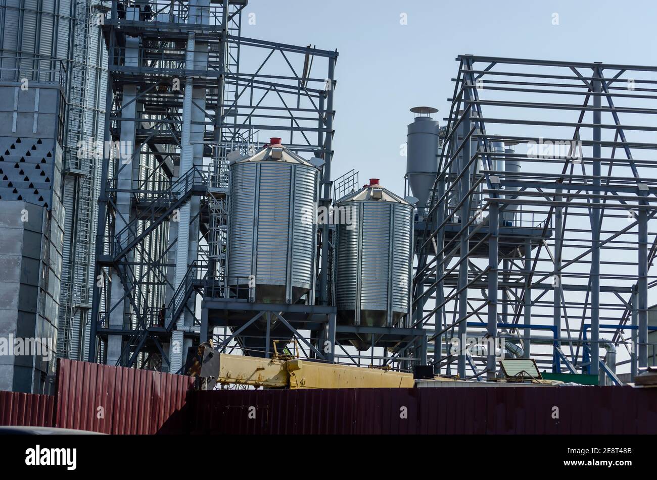 Construction of a modern grain terminal on a blue sky background. Metal ...