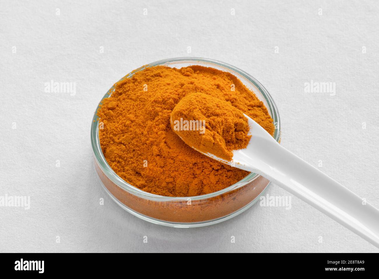 turmeric powder in a small glass container and a spoon Stock Photo - Alamy