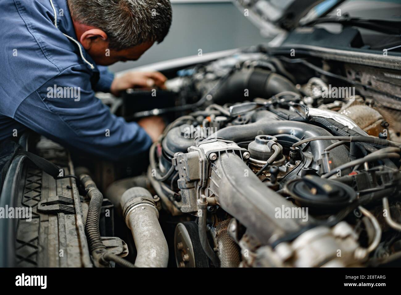 Auto mechanic man checks car engine under the hood Stock Photo - Alamy