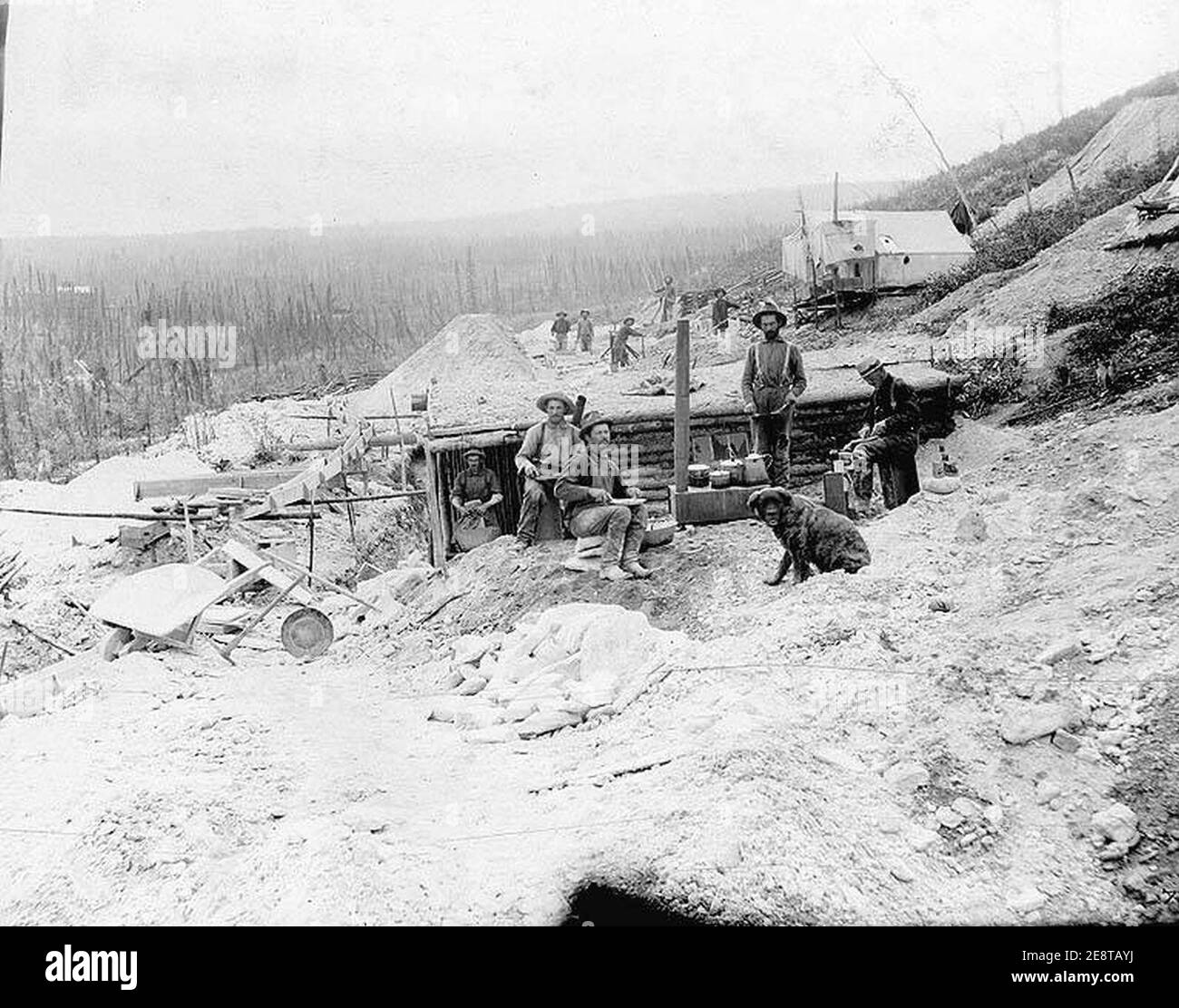 Mining operation showing miners working, eating within view of cabins ...
