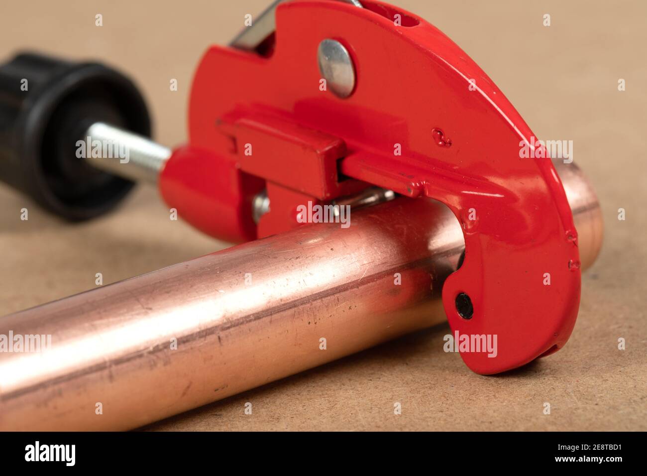 Cutting a copper pipe with a red pipe cutter Stock Photo - Alamy