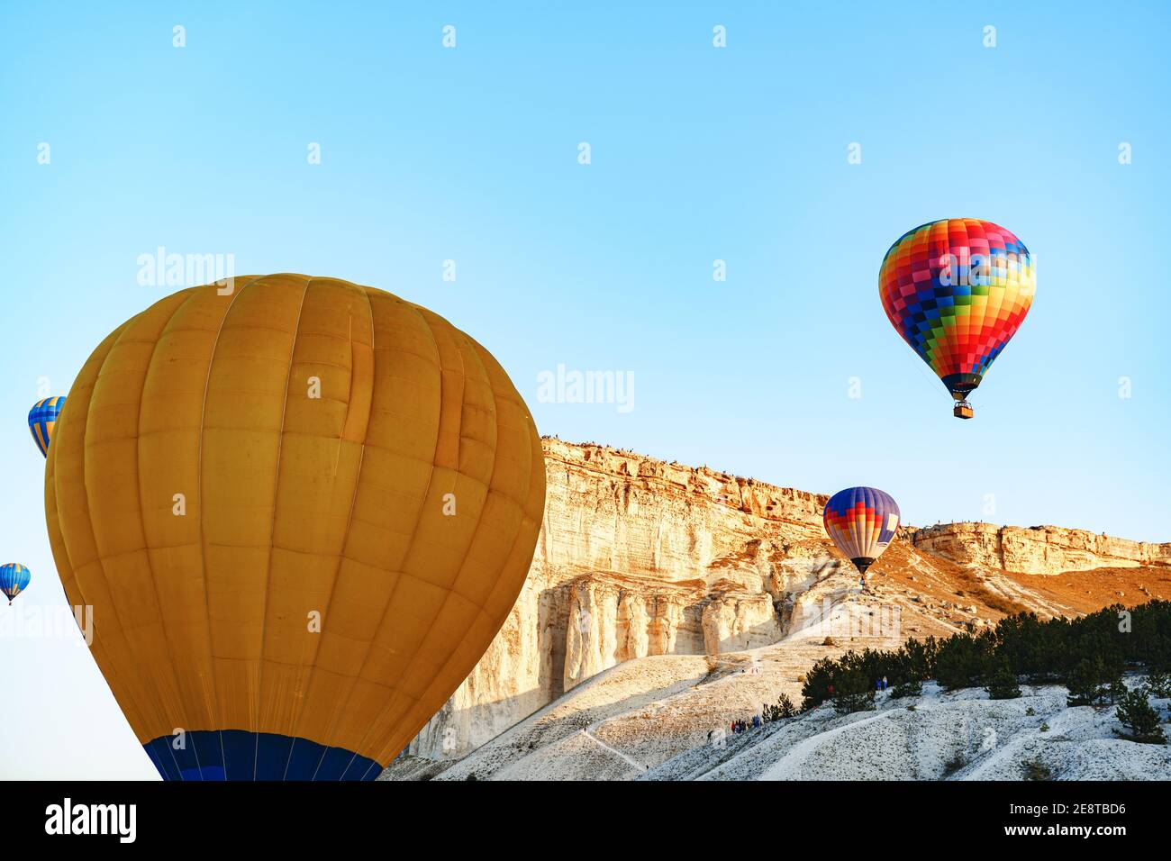 Colorful air balloons flying in clear sky near huge white mountain Stock Photo - Alamy