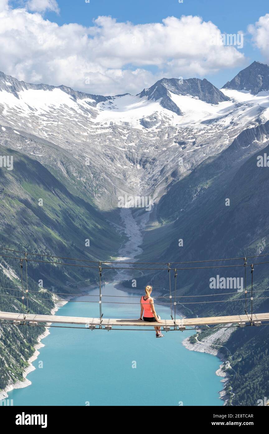 Female tourists sit on swing bridge with amazing view of reservoir ...