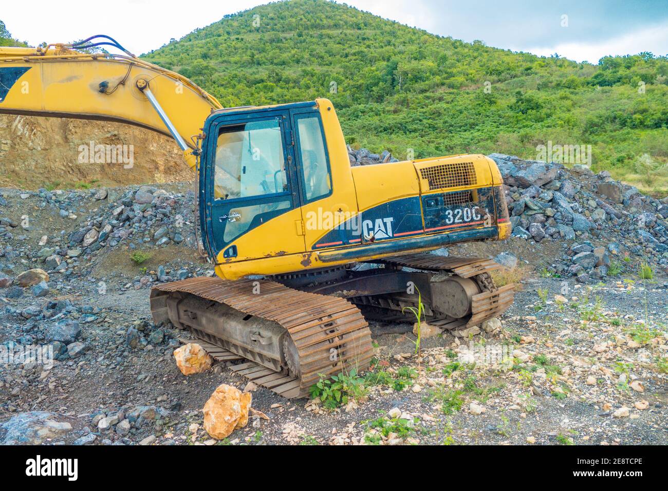 Bulldozer equip with drill, breaking down a hill landscape for homes ...