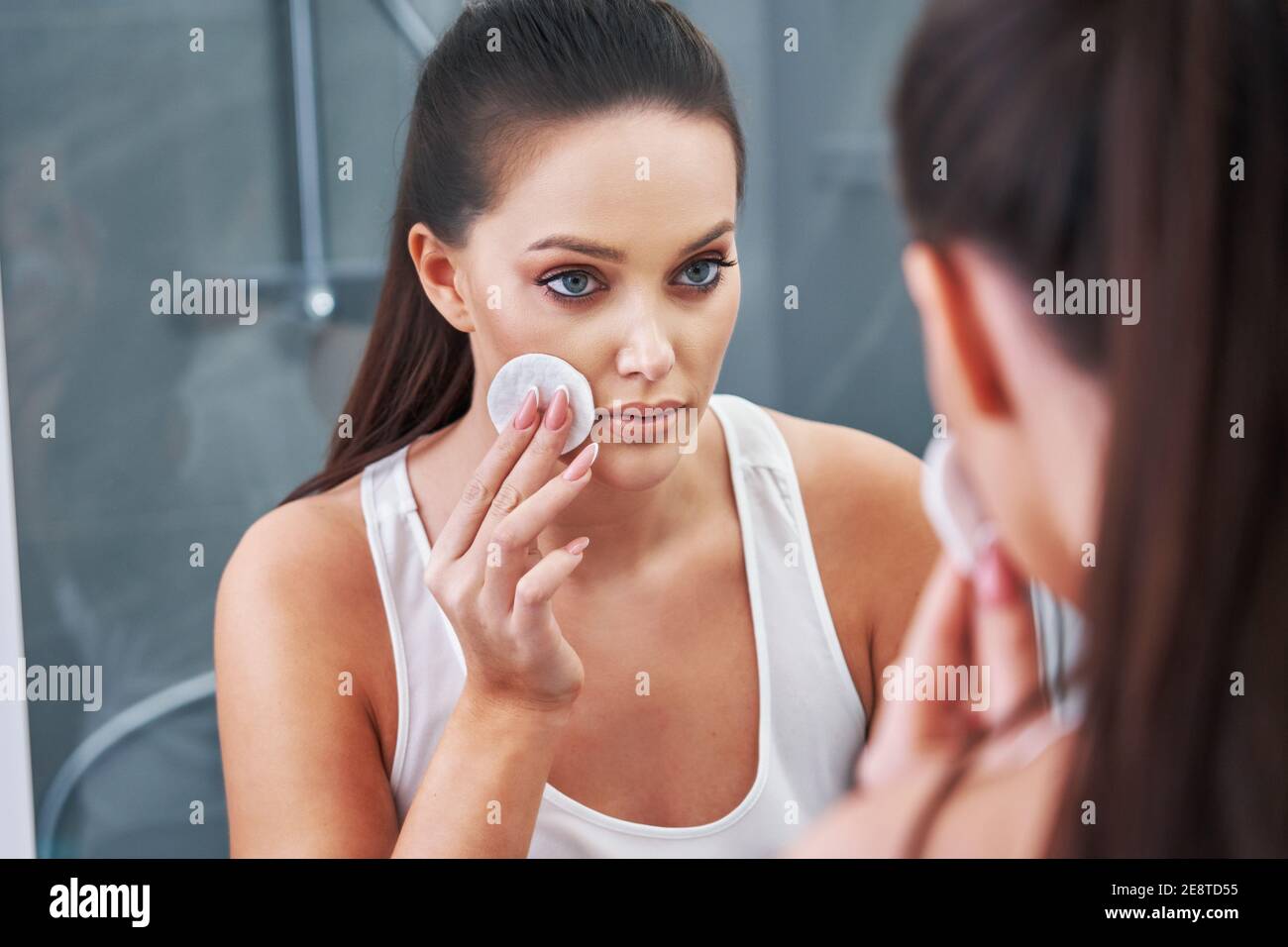 Woman looking on reflection in the mirror after shower Stock Photo - Alamy