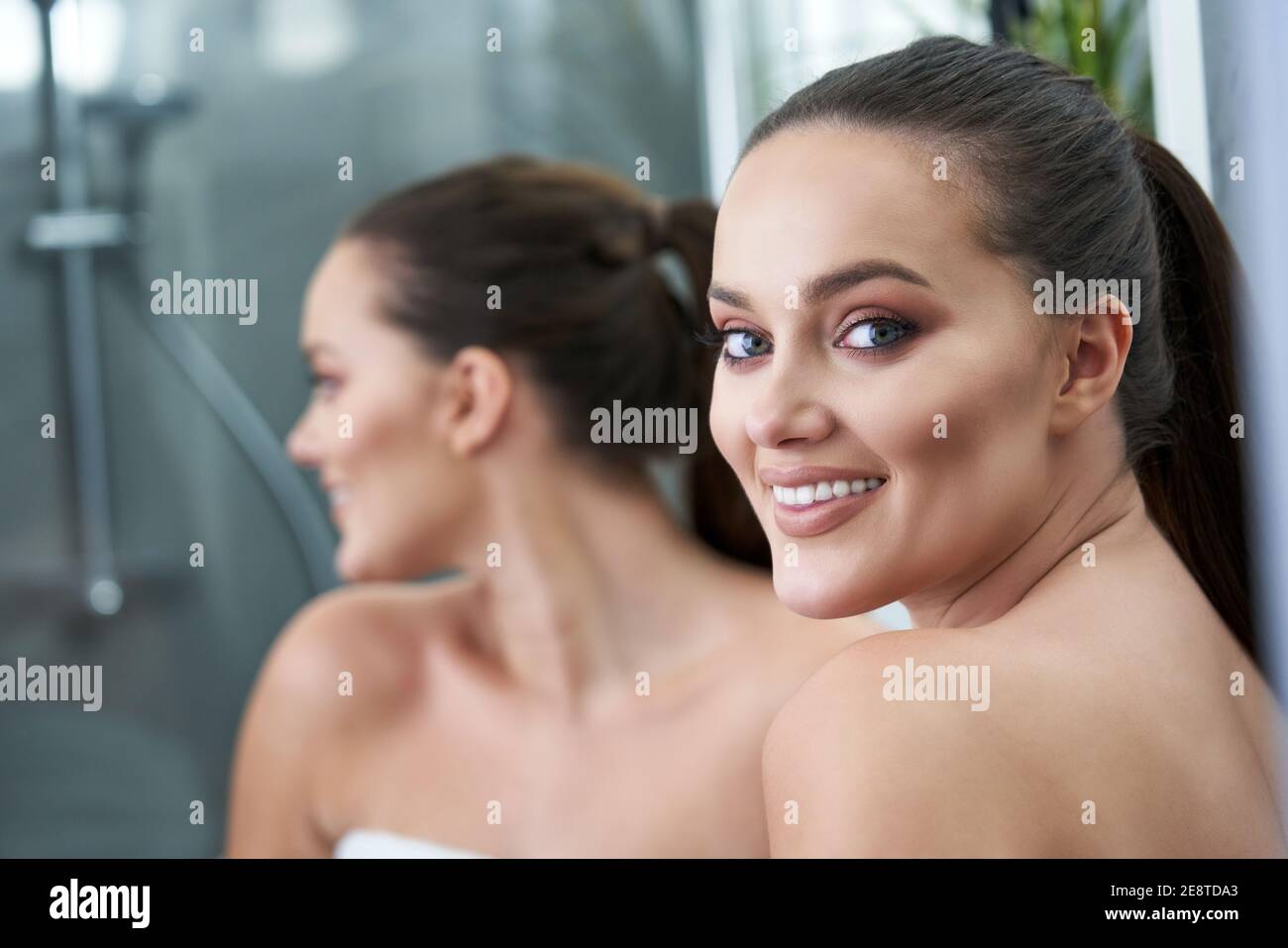 Woman looking on reflection in the mirror after shower Stock Photo - Alamy