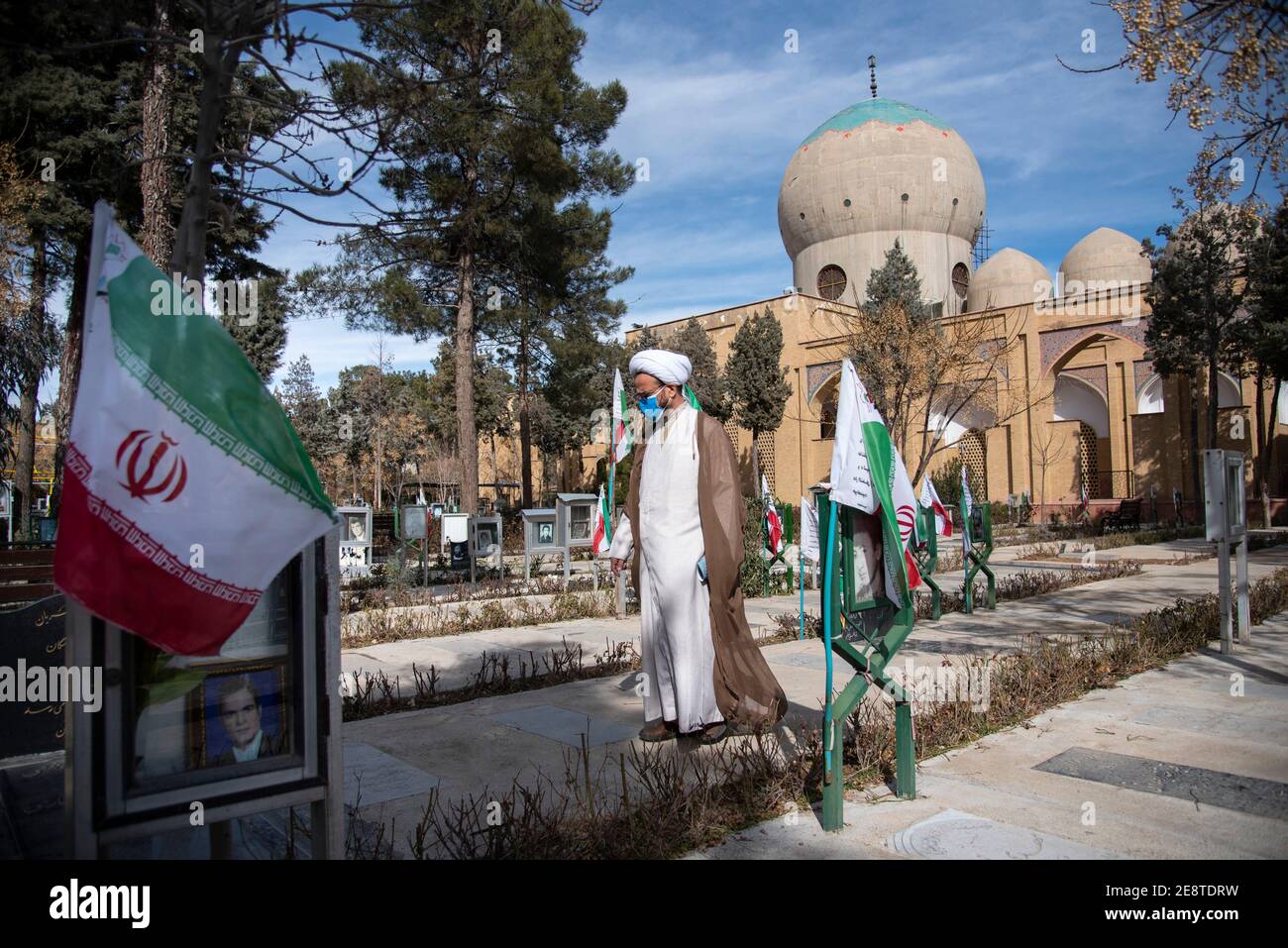 A mullah is passing by the grave of the martyrs of the islamic ...