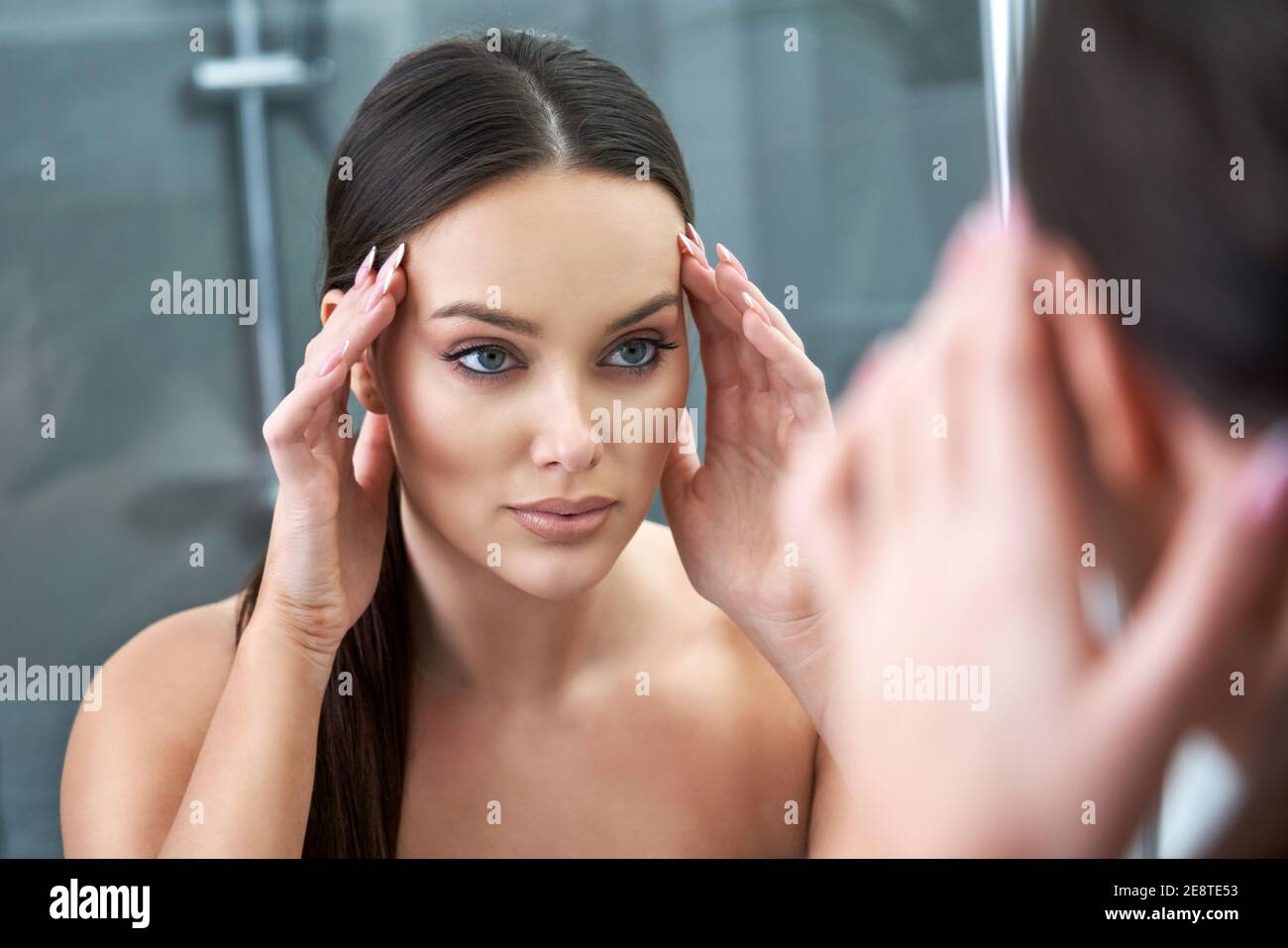 Woman looking on reflection in the mirror after shower Stock Photo - Alamy