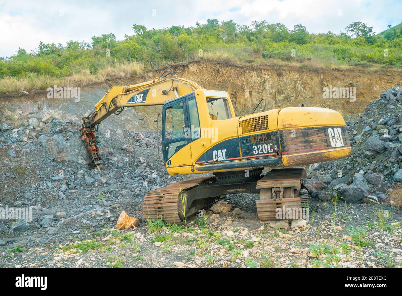 Bulldozer equip with drill, breaking down a hill landscape for homes ...