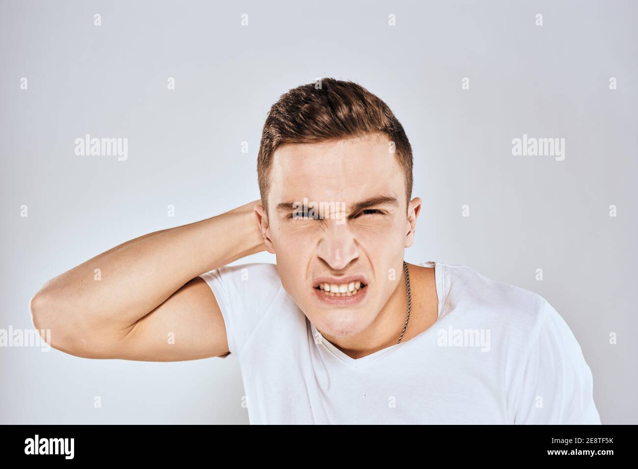 Man in white t-shirt displeased facial expression gesturing with hands ...