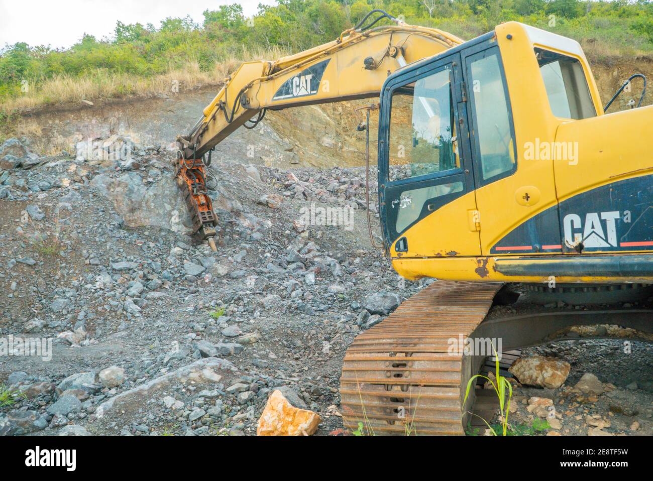 Bulldozer equip with drill, breaking down a hill landscape for homes ...