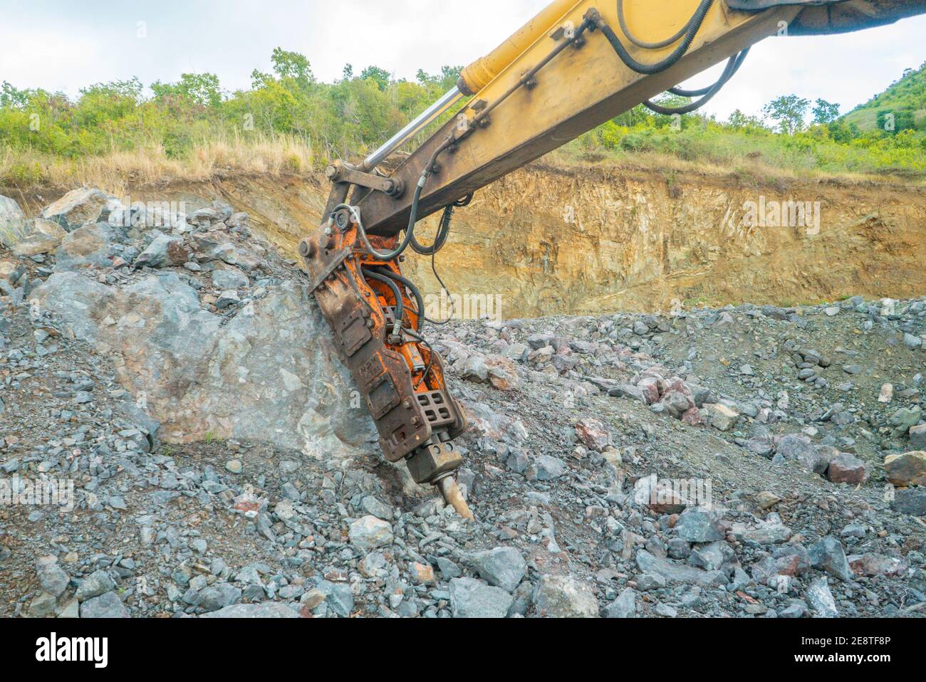 Bulldozer equip with drill, breaking down a hill landscape for homes ...