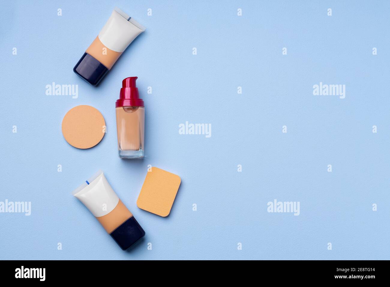 Complexion make up products and brush on blue background Stock Photo ...