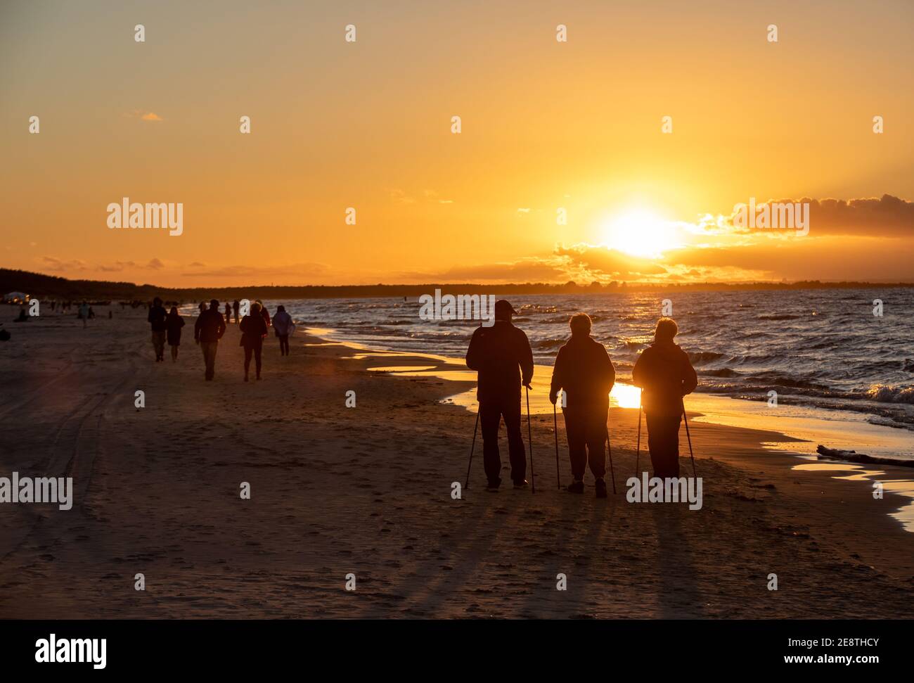 Active and healthy lifestyle. Nordic walking on a sandy beach sea shore ...