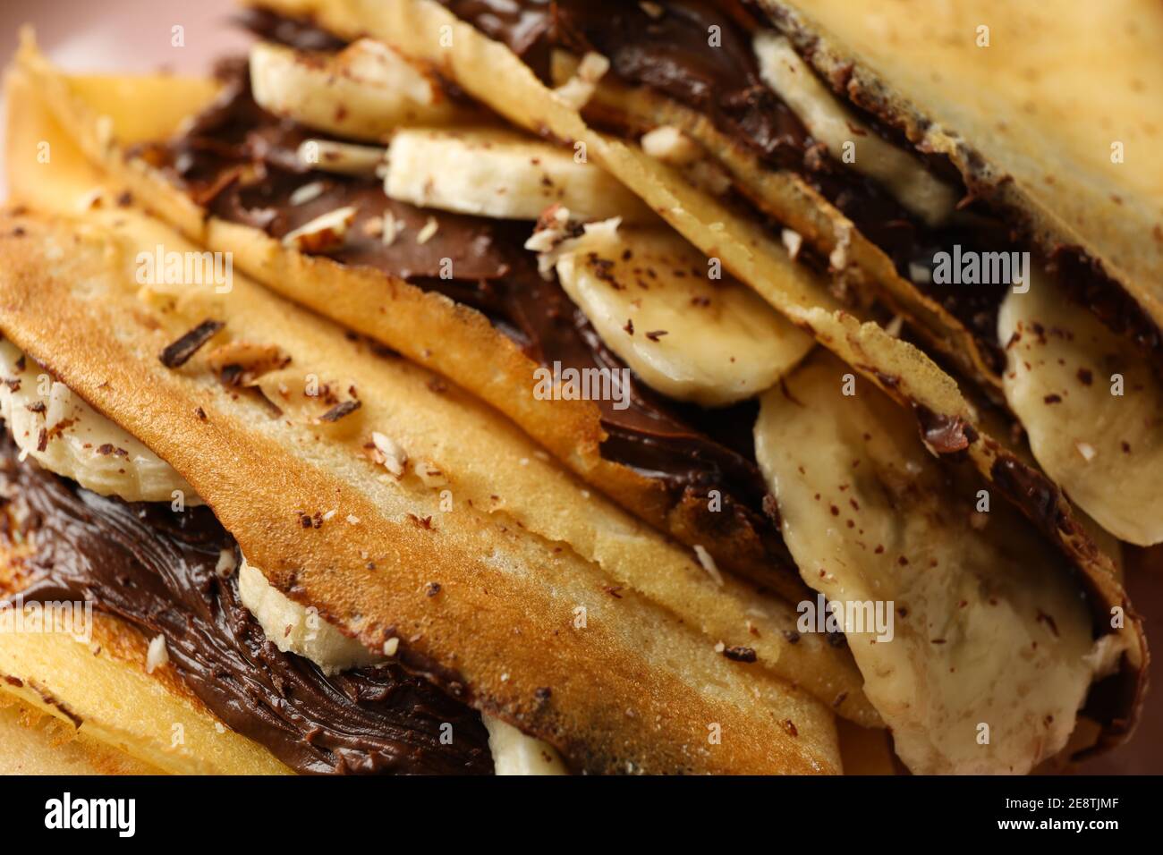 Delicious crepes with chocolate paste, banana and nuts, close up Stock ...
