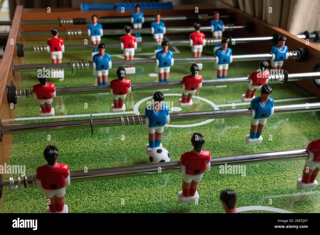 Table football, also known as table soccer, or foosball, with blue and ...