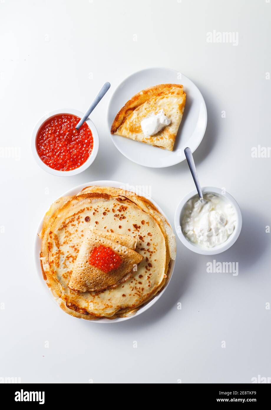 Traditional Russian Crepes Blini stacked in a plate with red caviar ...