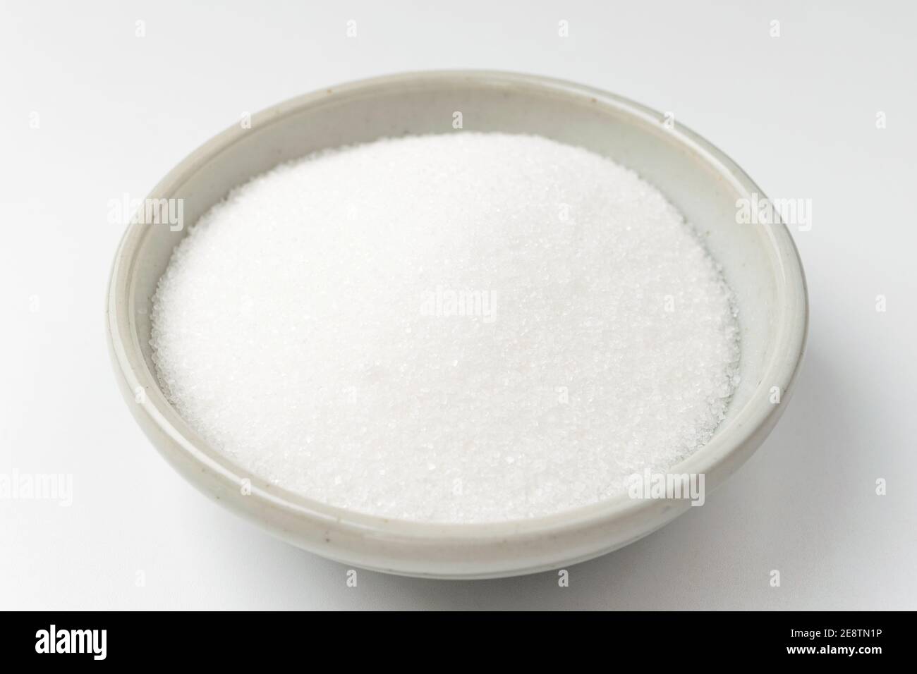 White sugar on white background Stock Photo - Alamy