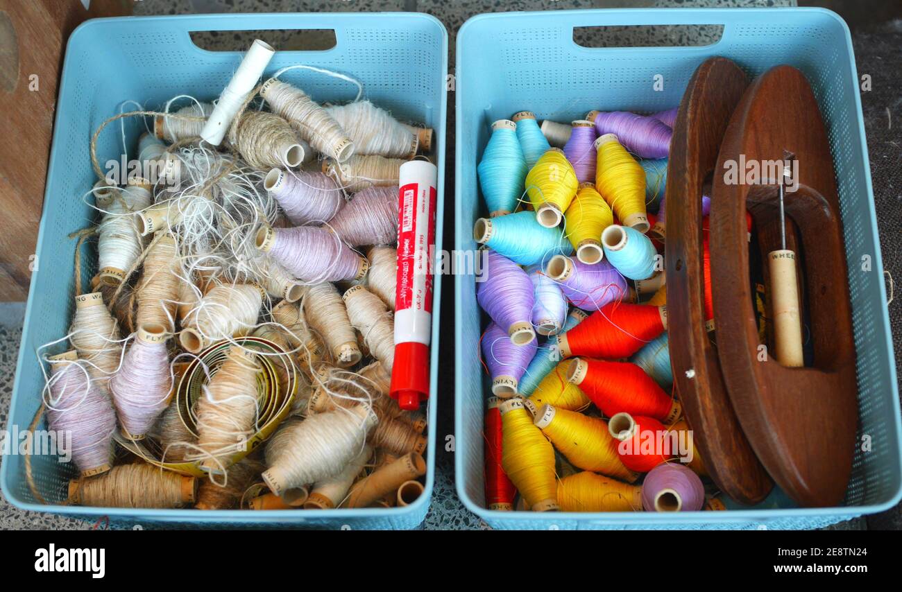Colourful cotton threads on bobbins, and shuttles in plastic boxes ...