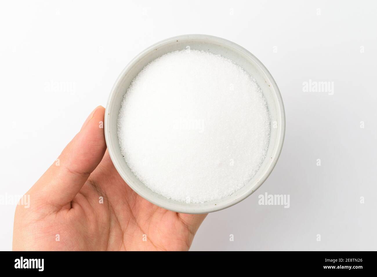 White sugar on white background Stock Photo - Alamy