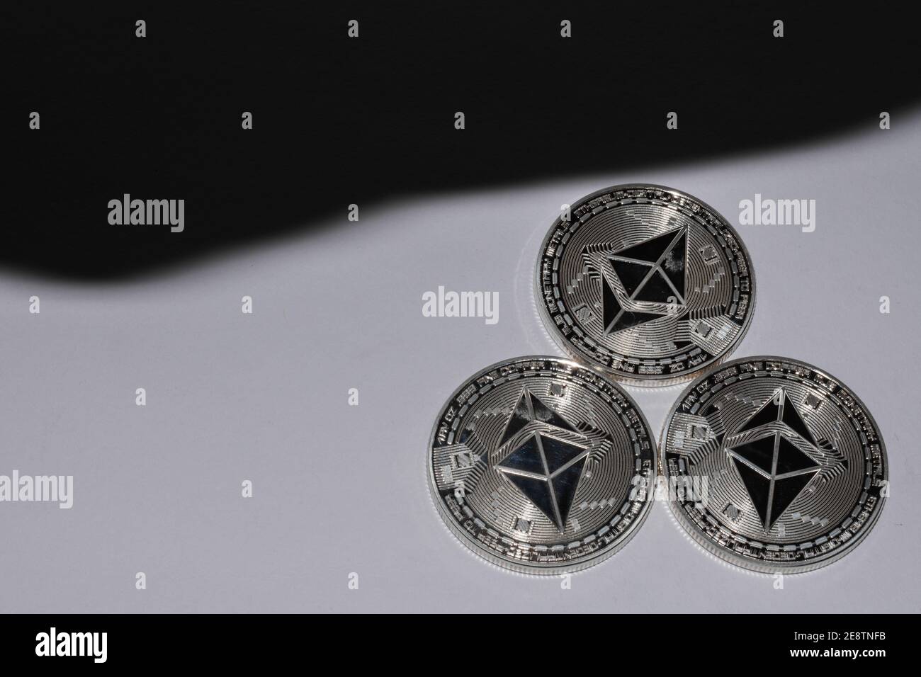 three silver ether coins from cryptocurrency on white background and ...