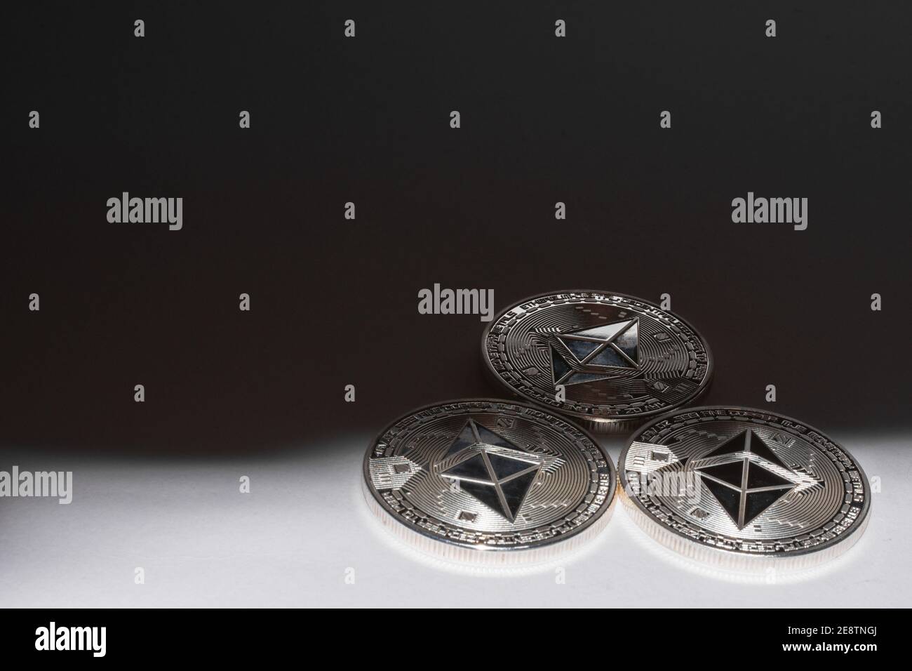 three silver ether coins from cryptocurrency half white and black ...