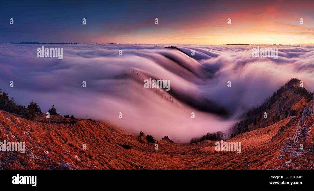 Sunset in the autumn mountains above the clouds during the weather ...