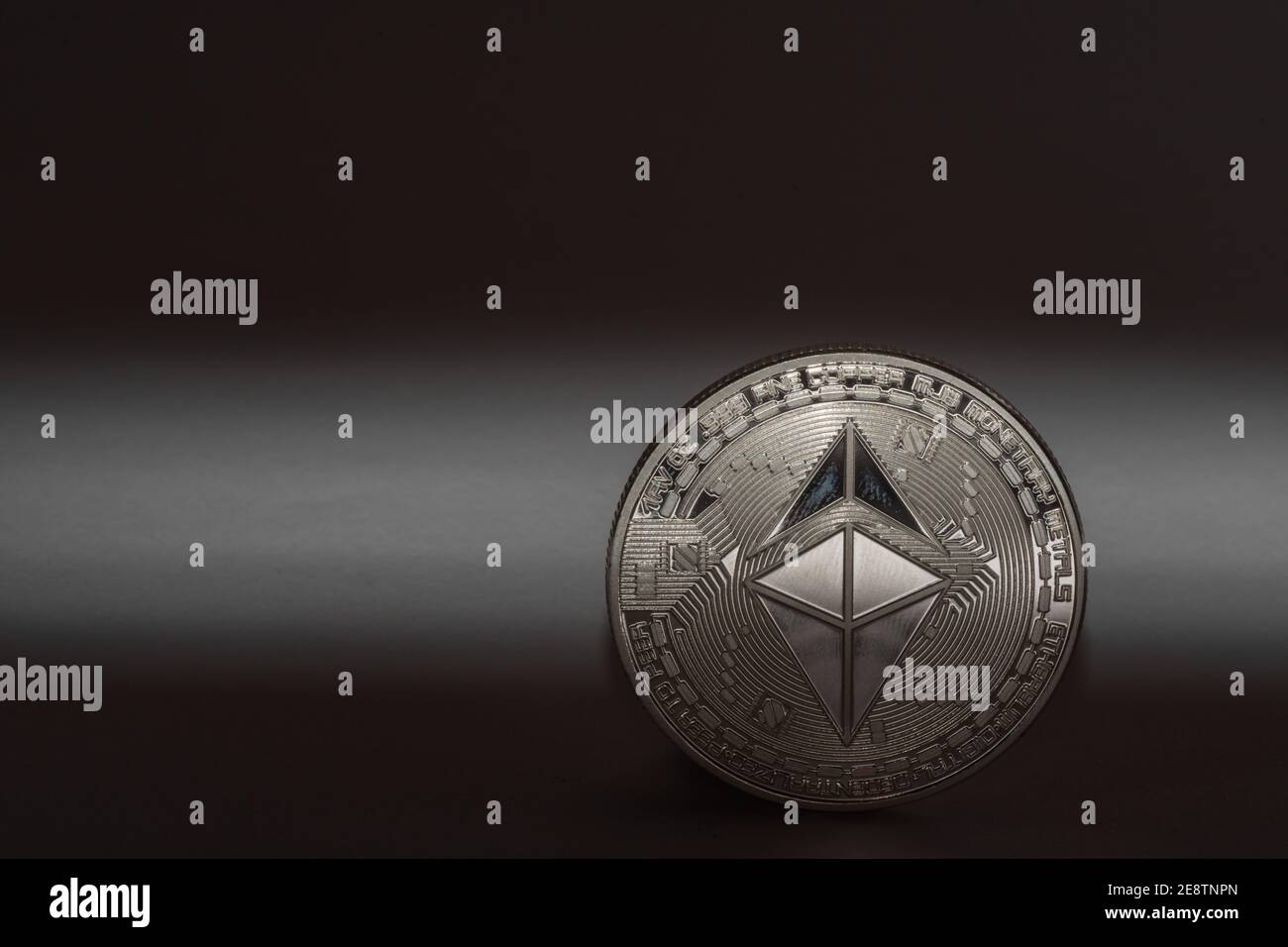 single ether coin from cryptocurrency with shadow on black background ...